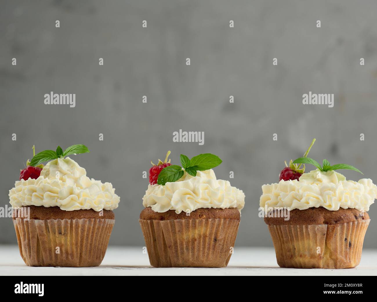 Baked cupcakes with white butter cream on the table, delicious dessert ...