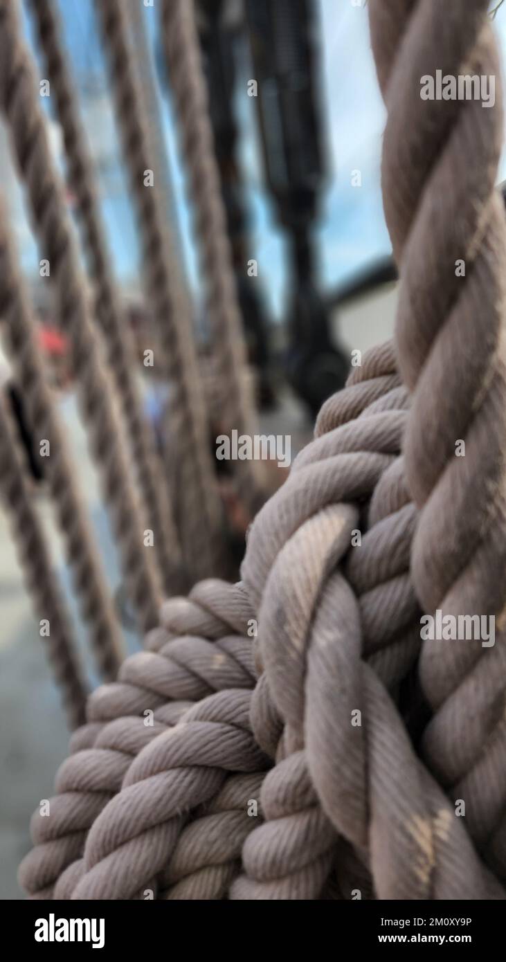 A vertical close up of ropes and rigging on an old sail ship holding up ...