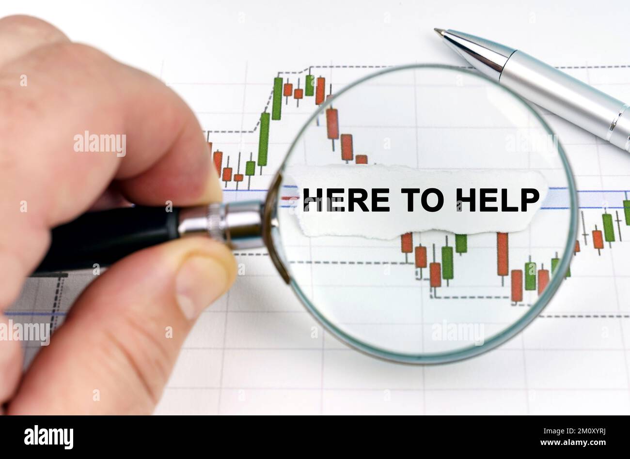 Economy concept. A man looks through a magnifying glass at charts and ...