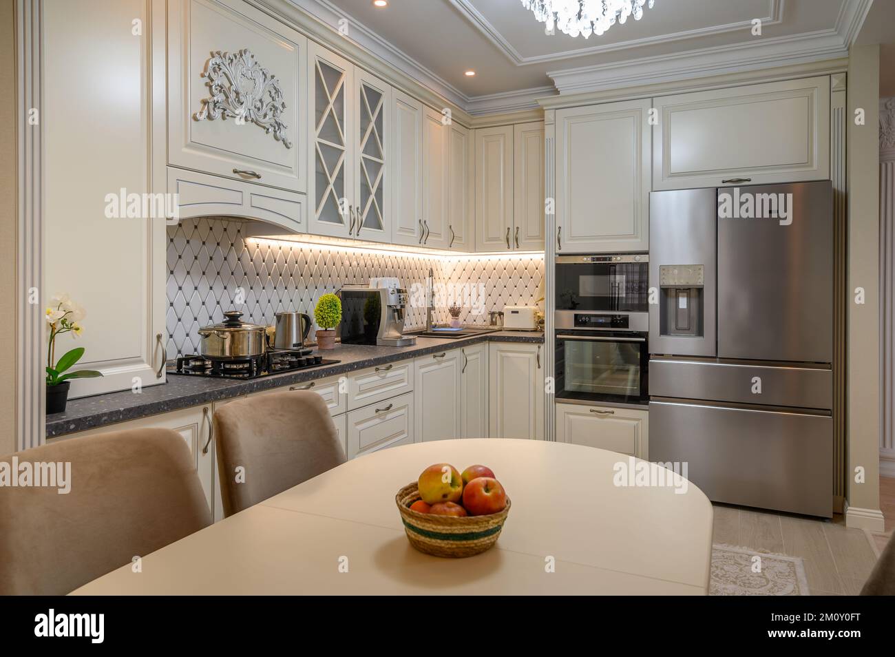Open-concept kitchen with a beige color scheme and classic design ...