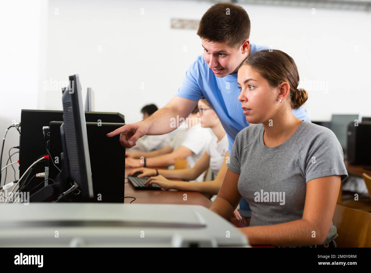 Teacher and teenage student studying in computer class Stock Photo - Alamy