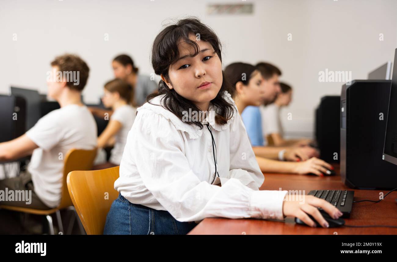Teenage girl using computer during lesson Stock Photo - Alamy