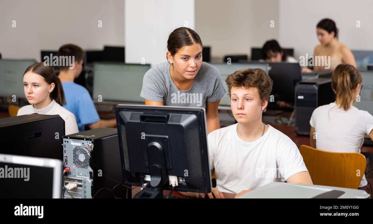 Teacher and teenage student studying in computer class Stock Photo - Alamy