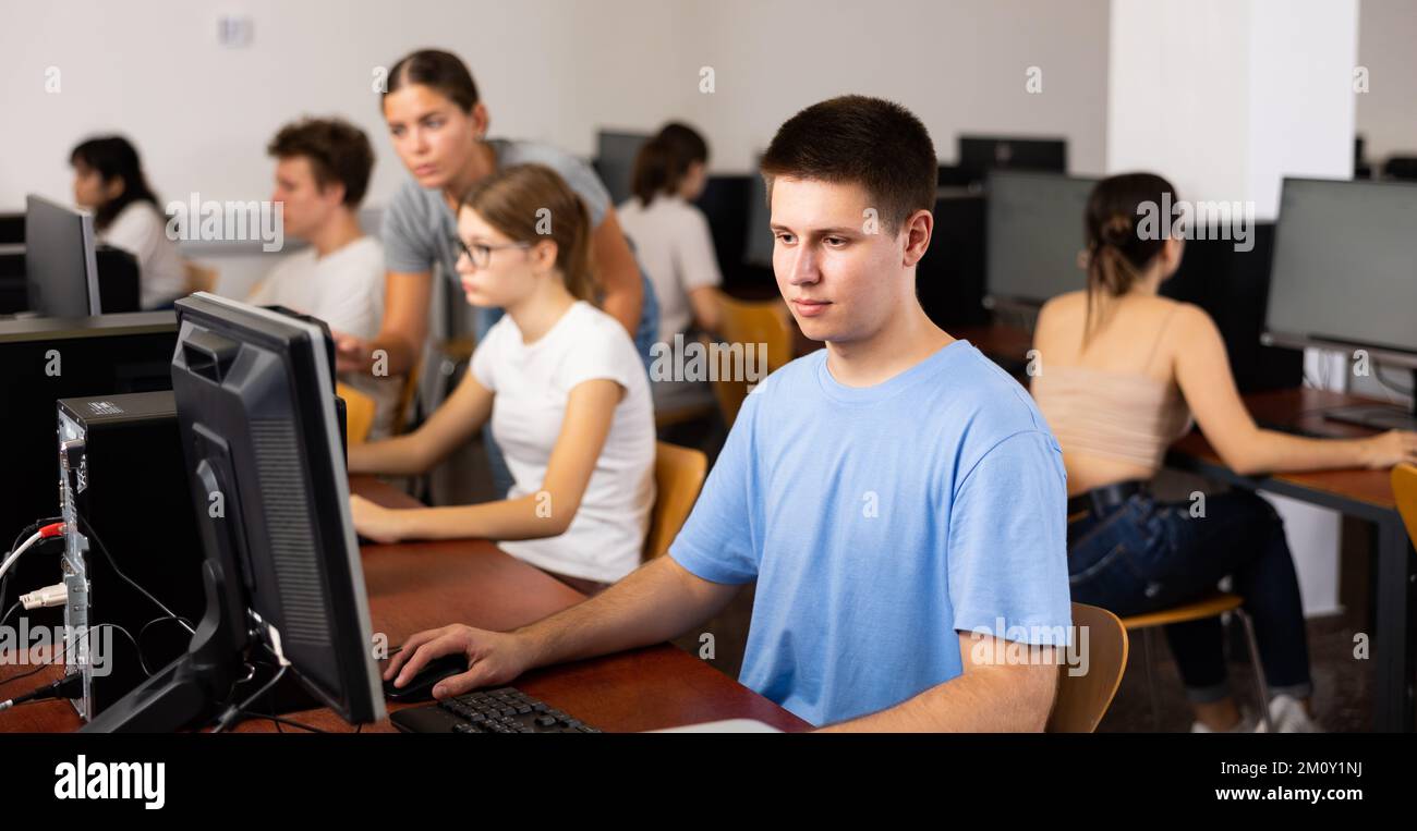 Teenage boy using computer during lesson Stock Photo - Alamy