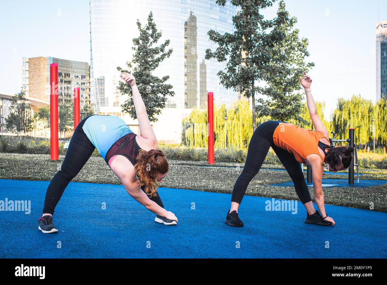 two young women training sport outdoor, stretching exercises before ...
