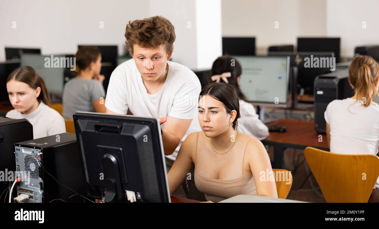 Teenage boy and girl using computer at library, watching videos Stock ...