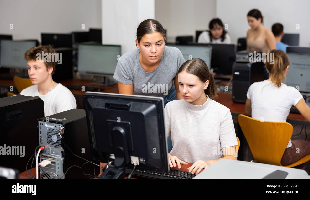 Woman teacher helps girl with learning on computer in schoolclass Stock ...