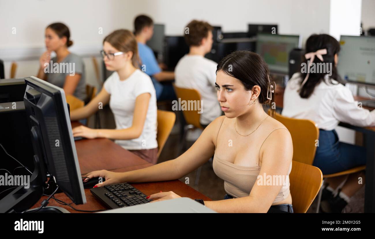 Smart Latin female teenager learning computer science while she is ...
