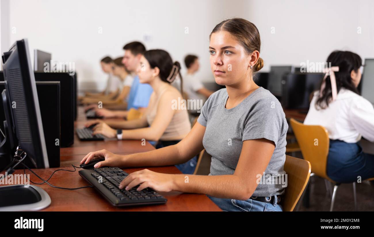 Concentrated female student using PC and studying computer science in ...
