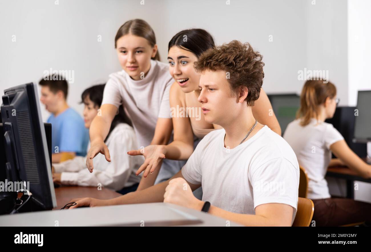 Cheerful teenager boy and girls studying in computer class Stock Photo ...