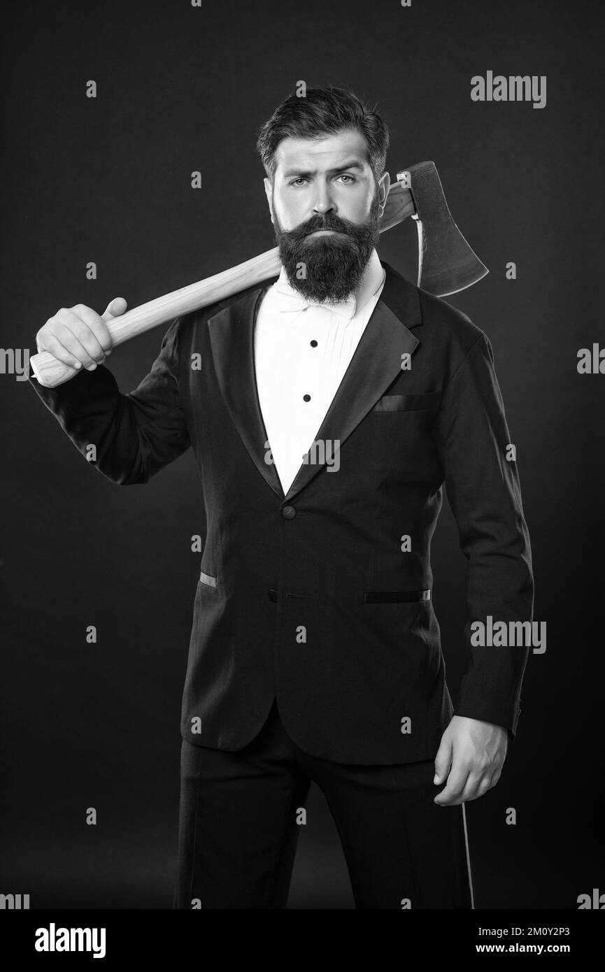 Serious unshaven man with beard and moustache in formal suit holding ...