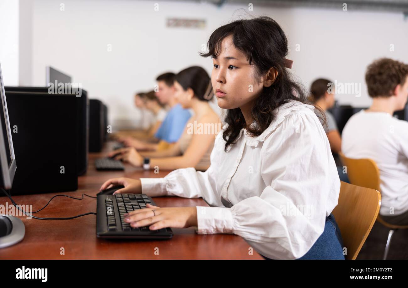 Teenage girl using computer during lesson Stock Photo - Alamy