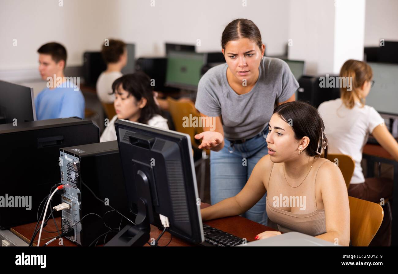 Schoolgirl and teacher using PC in computer class Stock Photo - Alamy