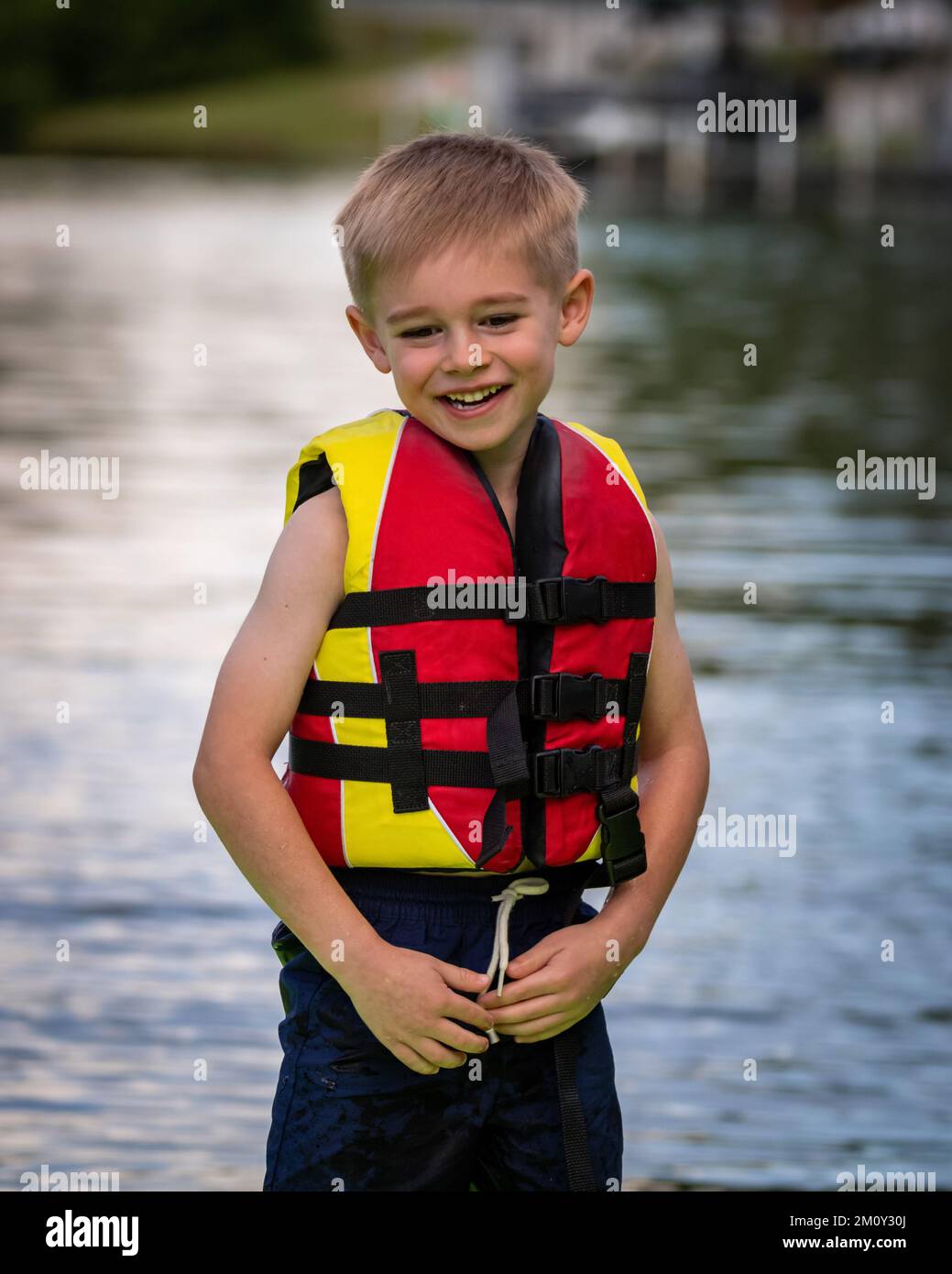 A blond boy wearing a life jacket Stock Photo - Alamy