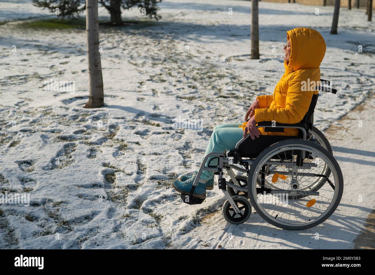 Caucasian woman with disabilities rides on a chair in the park in ...