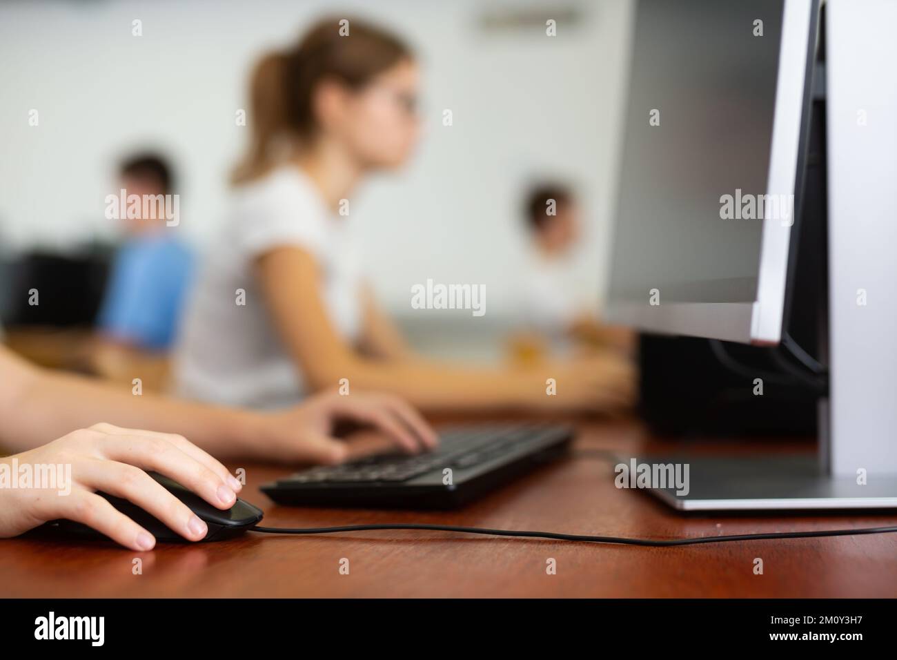 Blurred photo of female teenager in glasses learning computer science ...