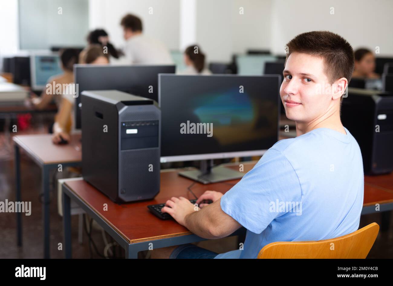 Cheerful teenager boy using PC during computer science lesson Stock ...
