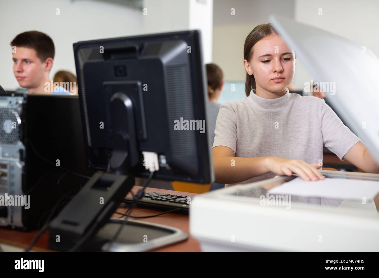 Teenage girl using scanner in computer class Stock Photo - Alamy