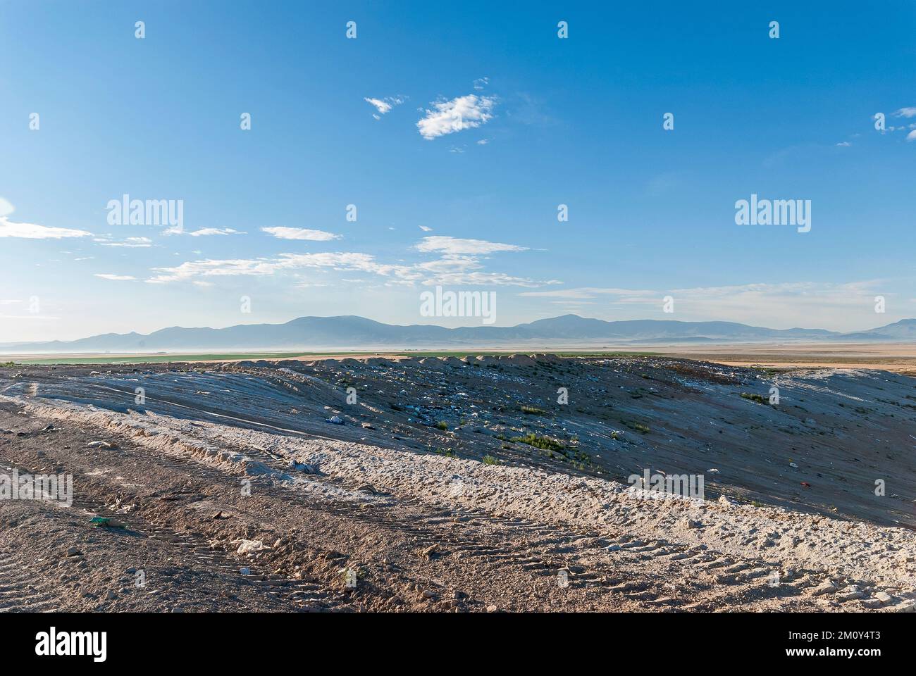 A large depression in the ground, with heavy equipment tracks in an ...
