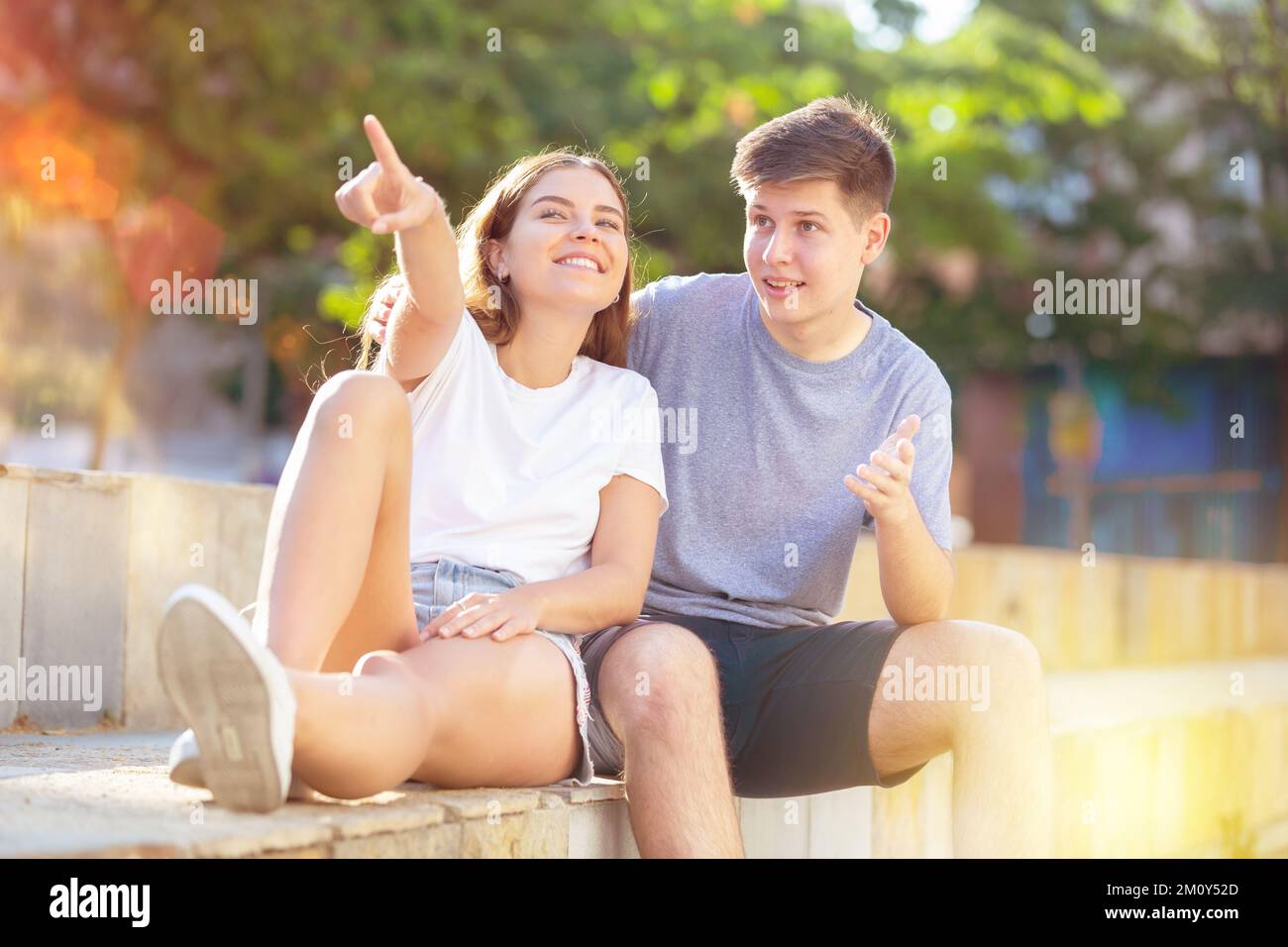 Girl prompts the boy, pointing with his hand at something Stock Photo ...