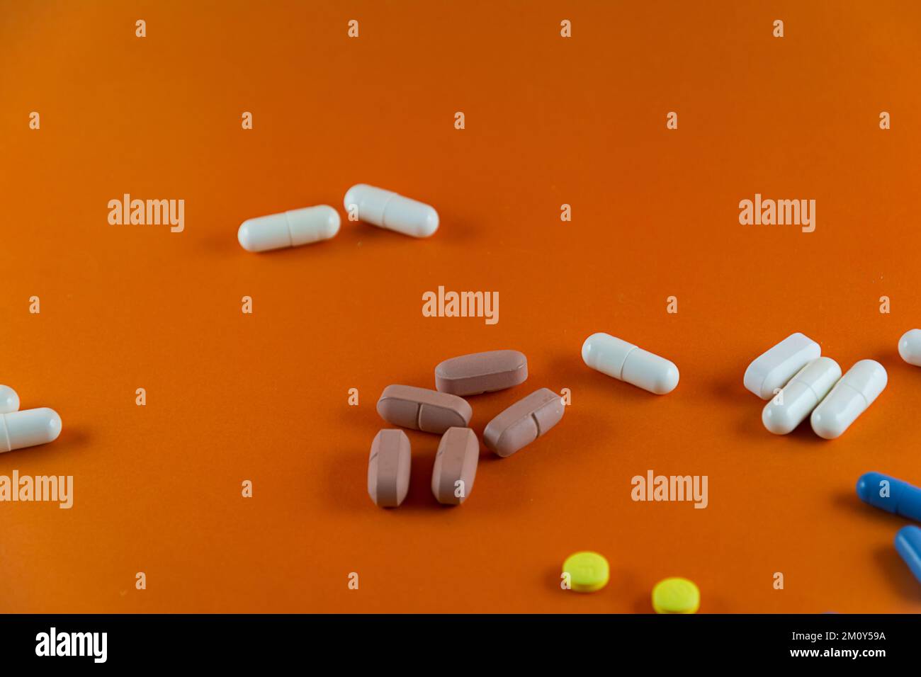 Different pills of brown white blue and yellow color scattered on ...