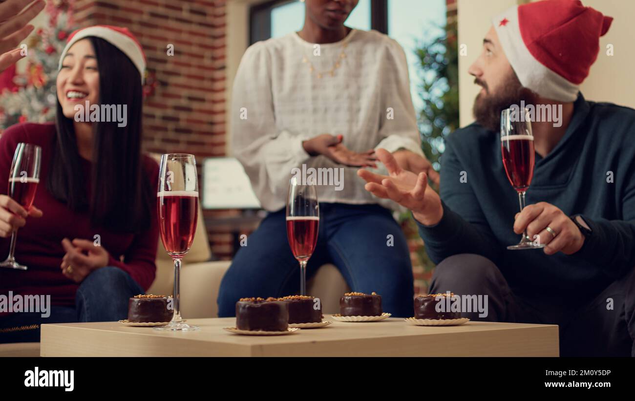 Diverse people drinking glasses of wine at holiday festivity in office ...