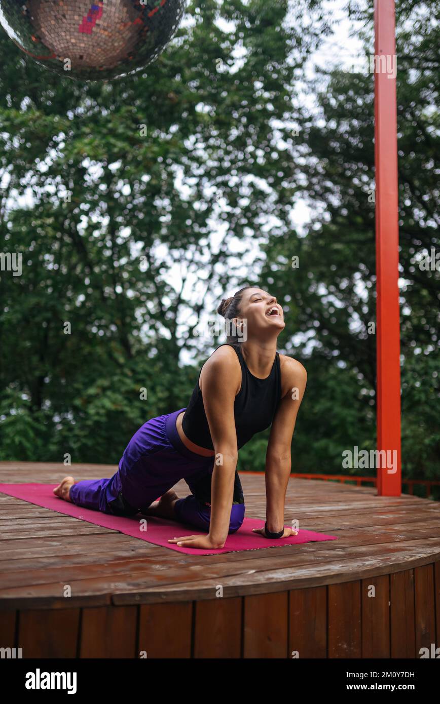 Sporty woman performs kneeling exercises while standing on a mat Stock ...