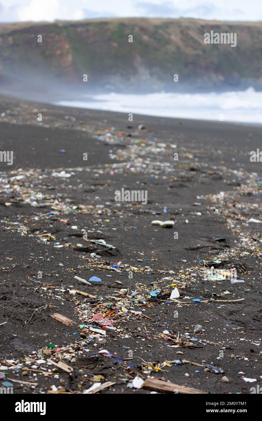 Trash in the sand, plastic waste by the ocean, sad and unsustainable ...