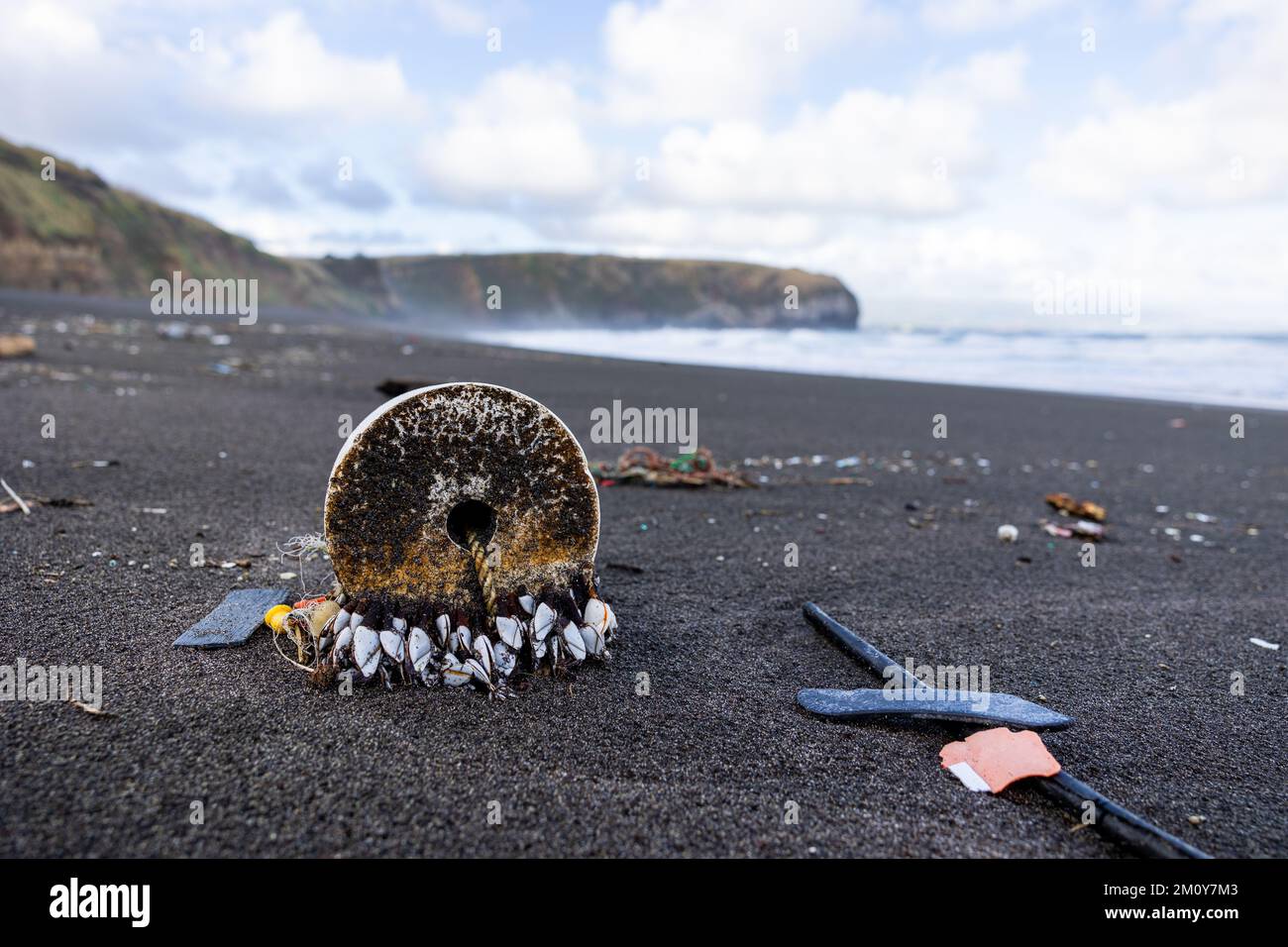 Trash in the sand, plastic waste by the ocean, sad and unsustainable ...