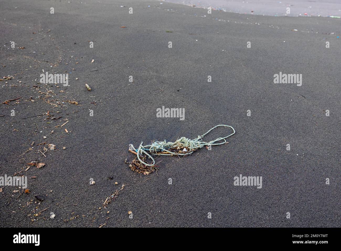 Trash in the sand, plastic waste by the ocean, sad and unsustainable ...