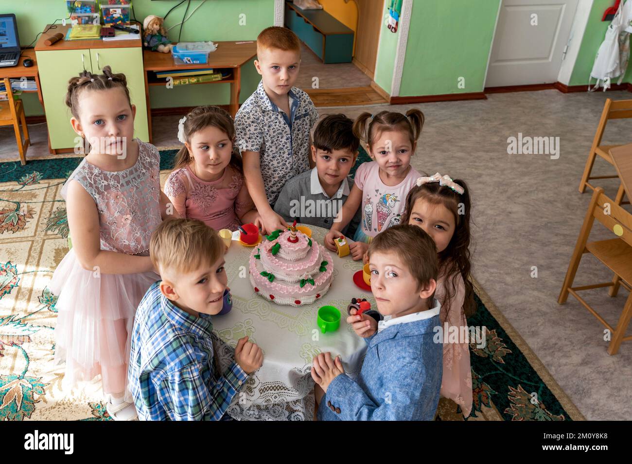 children with cake at the table look at the camera Stock Photo - Alamy