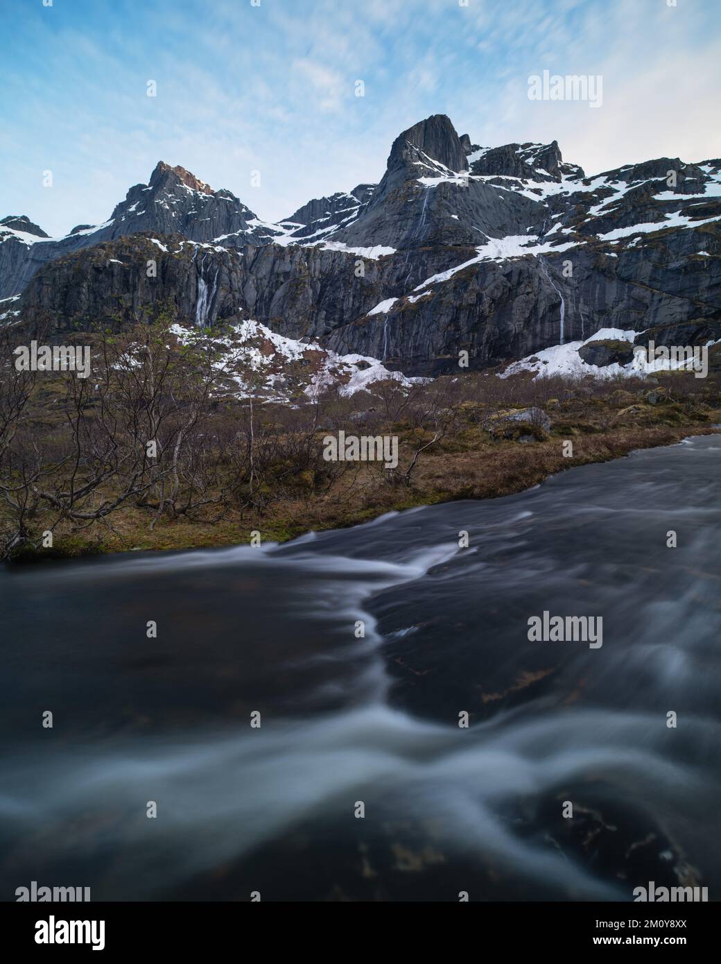 Mountain peaks rise above flowing stream, Lofoten Islands, Norway Stock ...