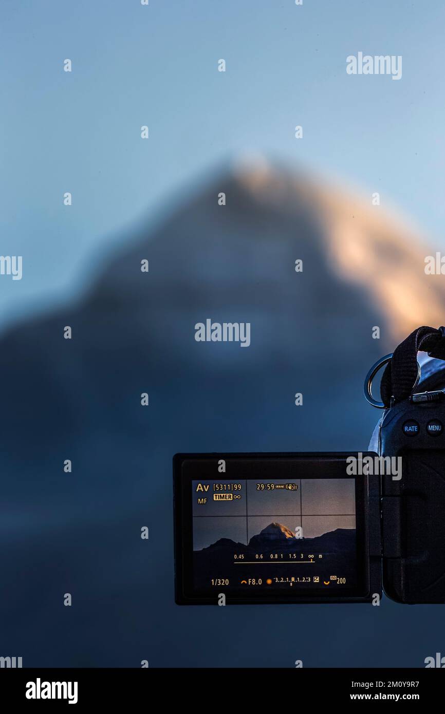 A vertical shot of a camera screen taking photo of the sunrise of Mount ...