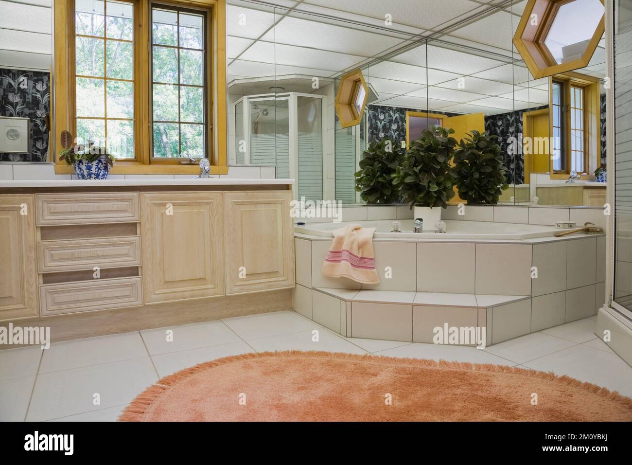 Vanity and soaking bathtub on podium in bathroom inside mixed decorated ...