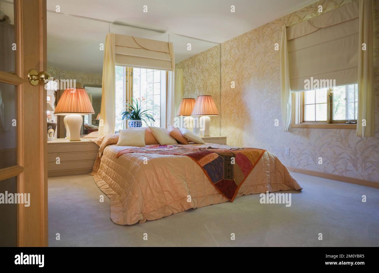 King size bed in master bedroom with large wall mirror inside mixed ...