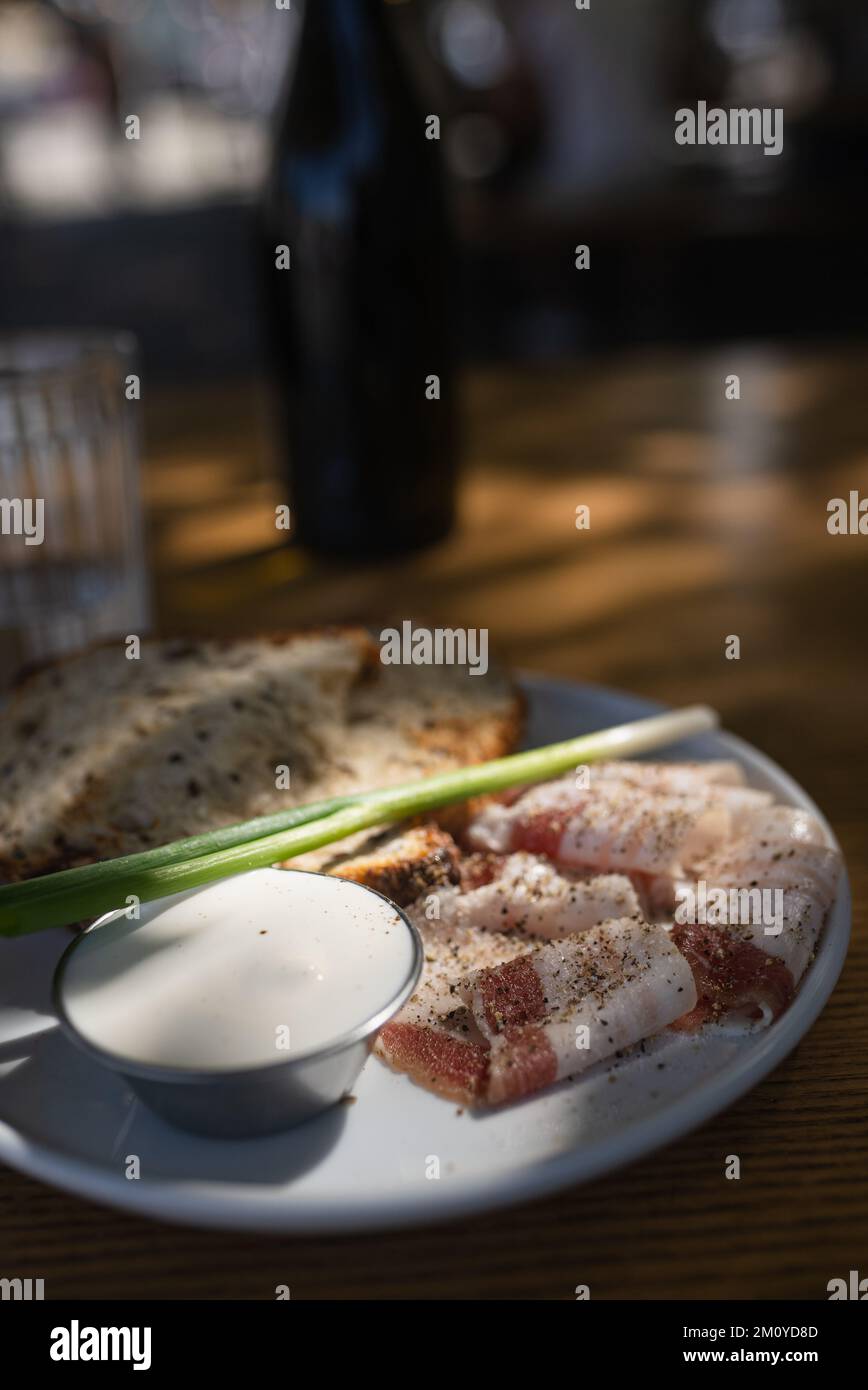 Close up view slices of smoked bacon meat with rye whole grain black ...