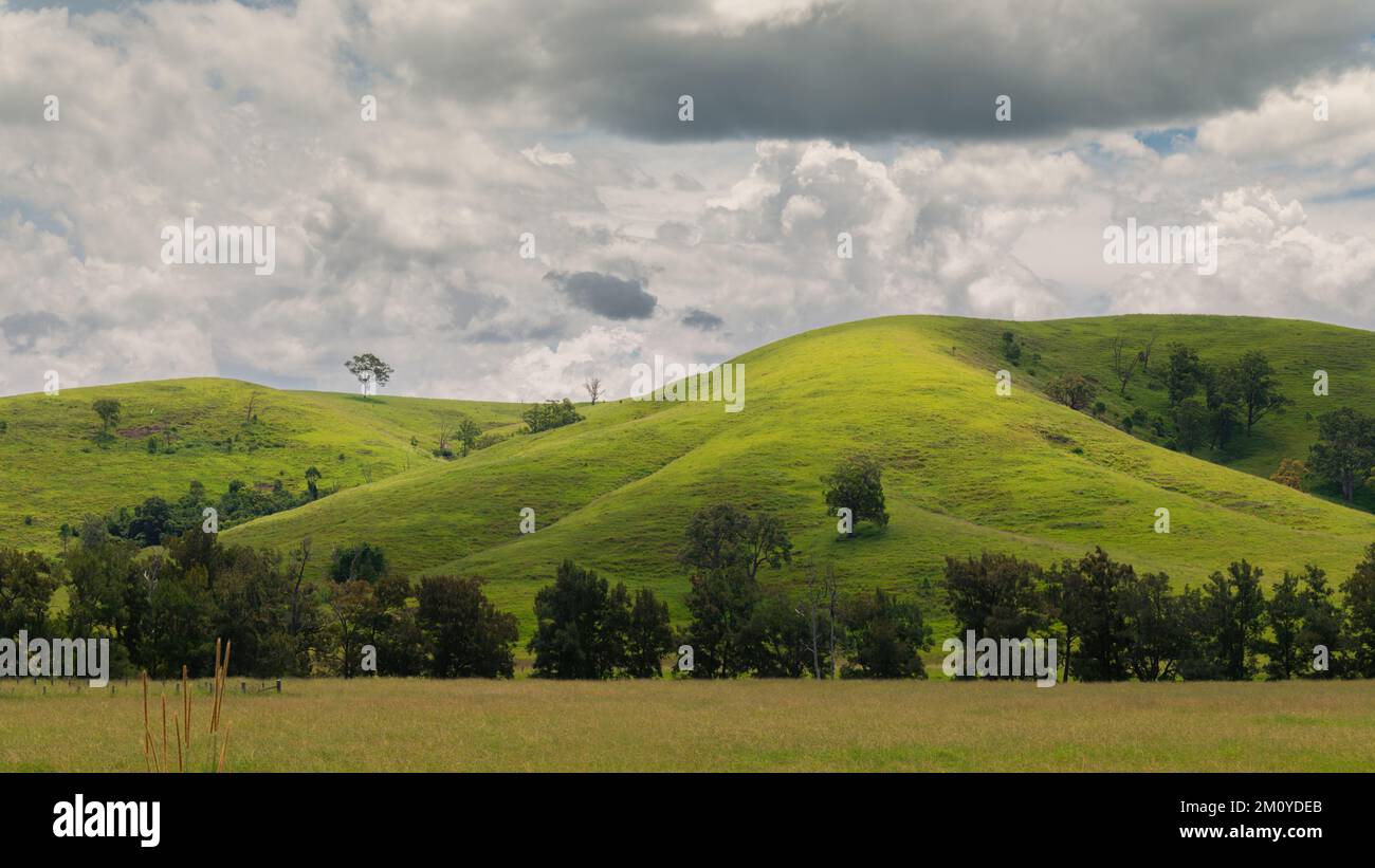 Scenic rural scene of rolling hills with trees and a cloudy sky ...