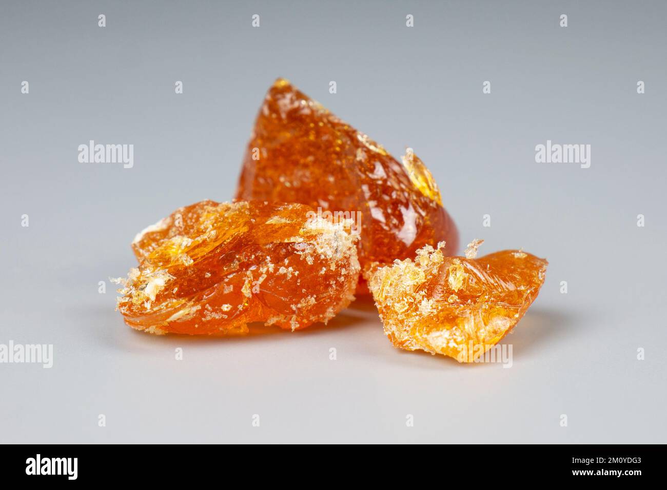 high thc dab bho, pieces of yellow cannabis wax and green leaf ...