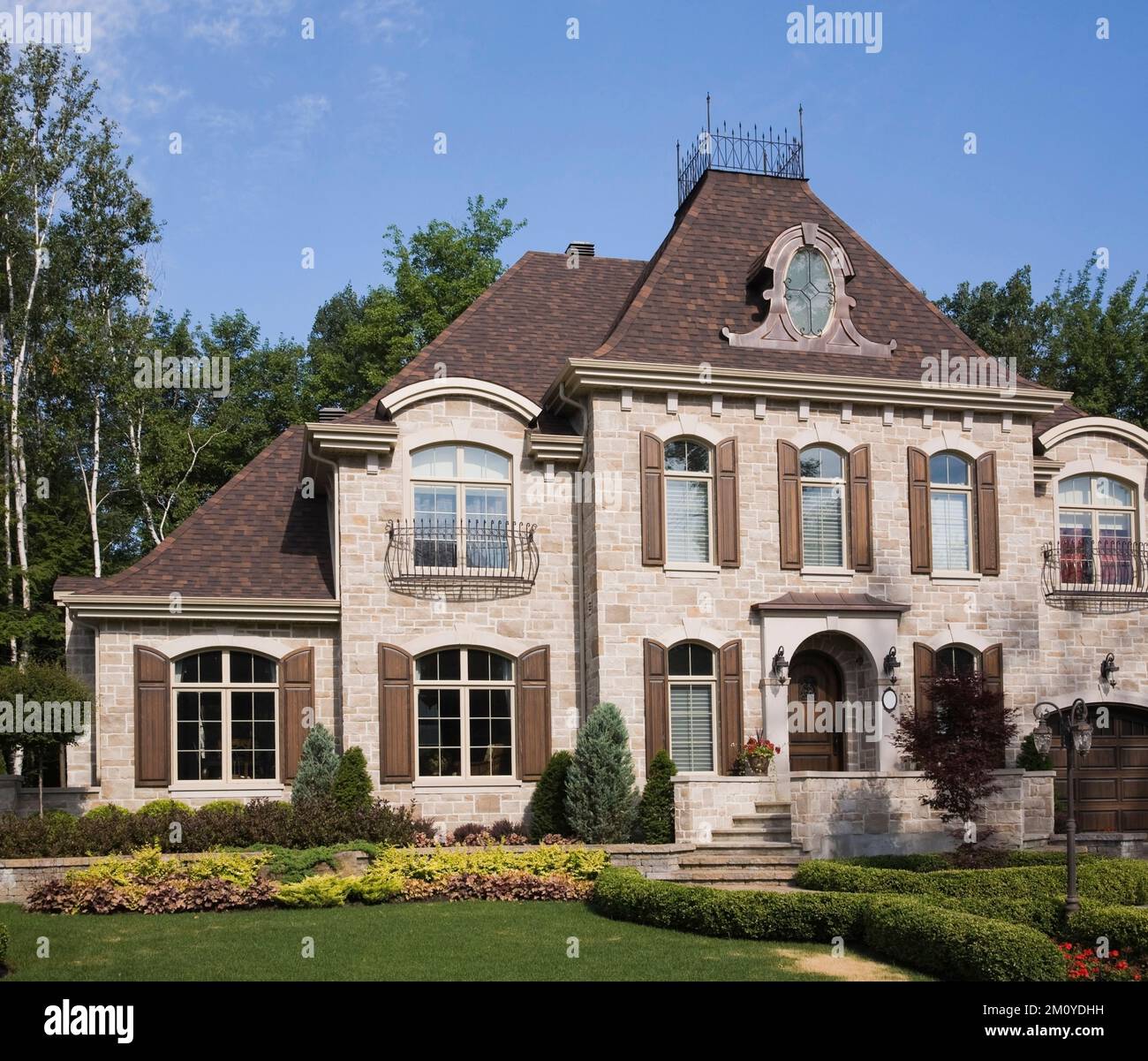 Luxurious nuanced beige and tan cut stone two story home facade with ...