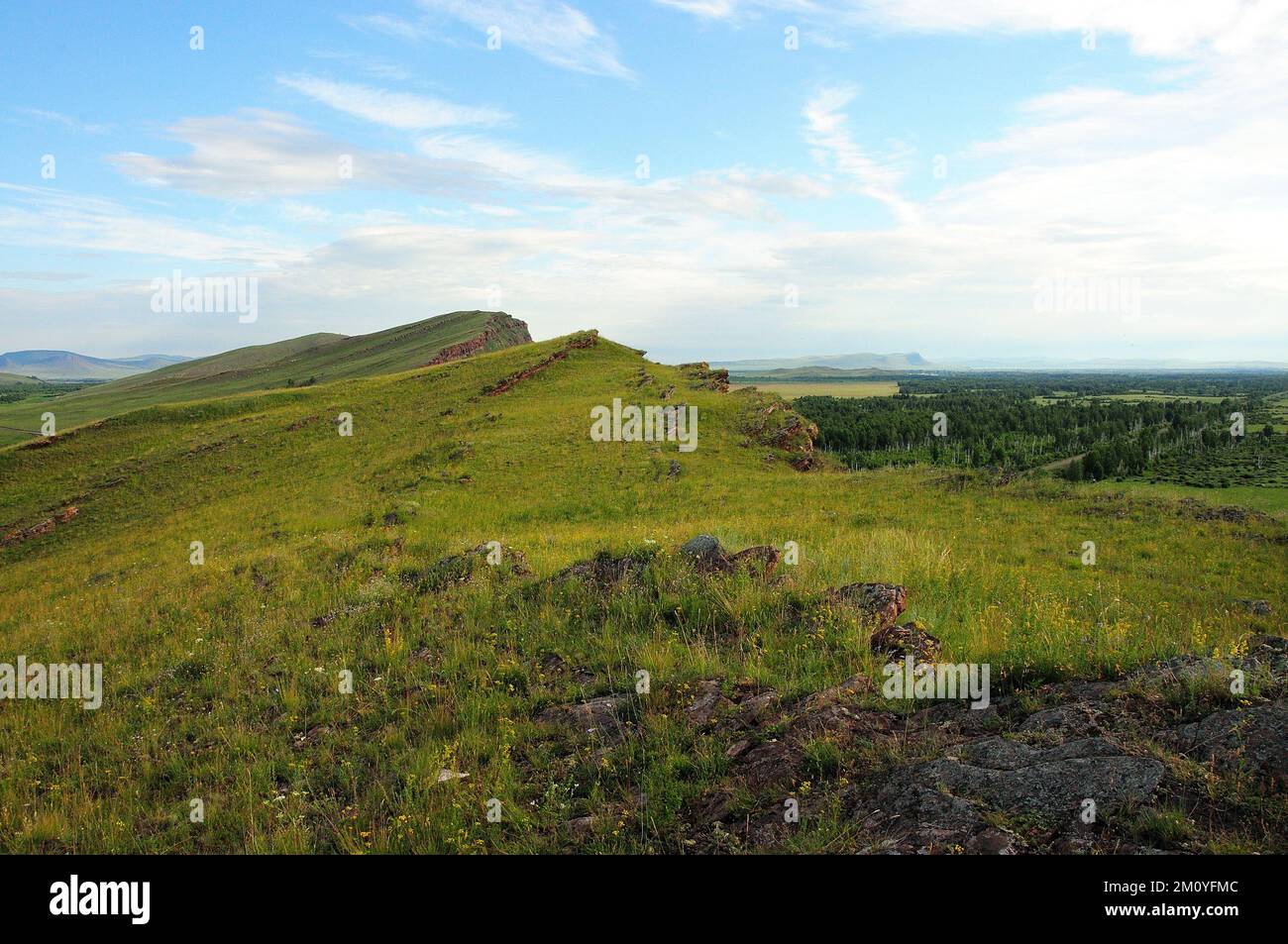 A series of high hills with rocky formations on top overlooking a ...