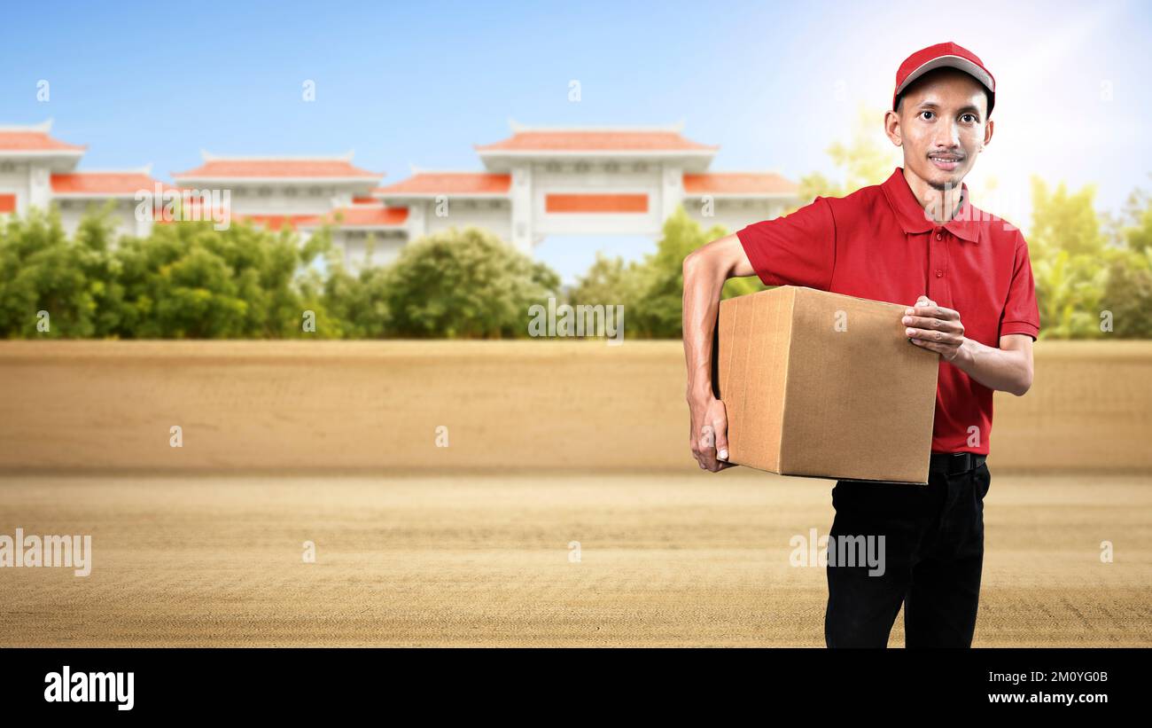 Parcel delivery man with a hat carrying a package in the city Stock ...