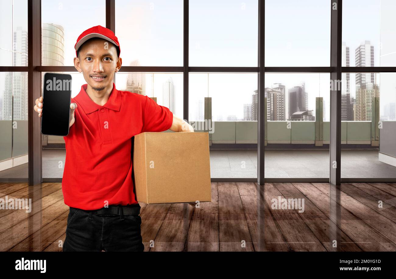 Parcel delivery man with a hat showing his mobile phone screen while ...