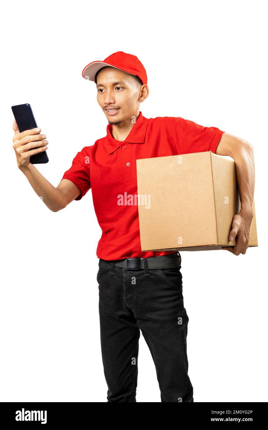 Parcel delivery man with a hat holding a mobile phone while carrying a ...