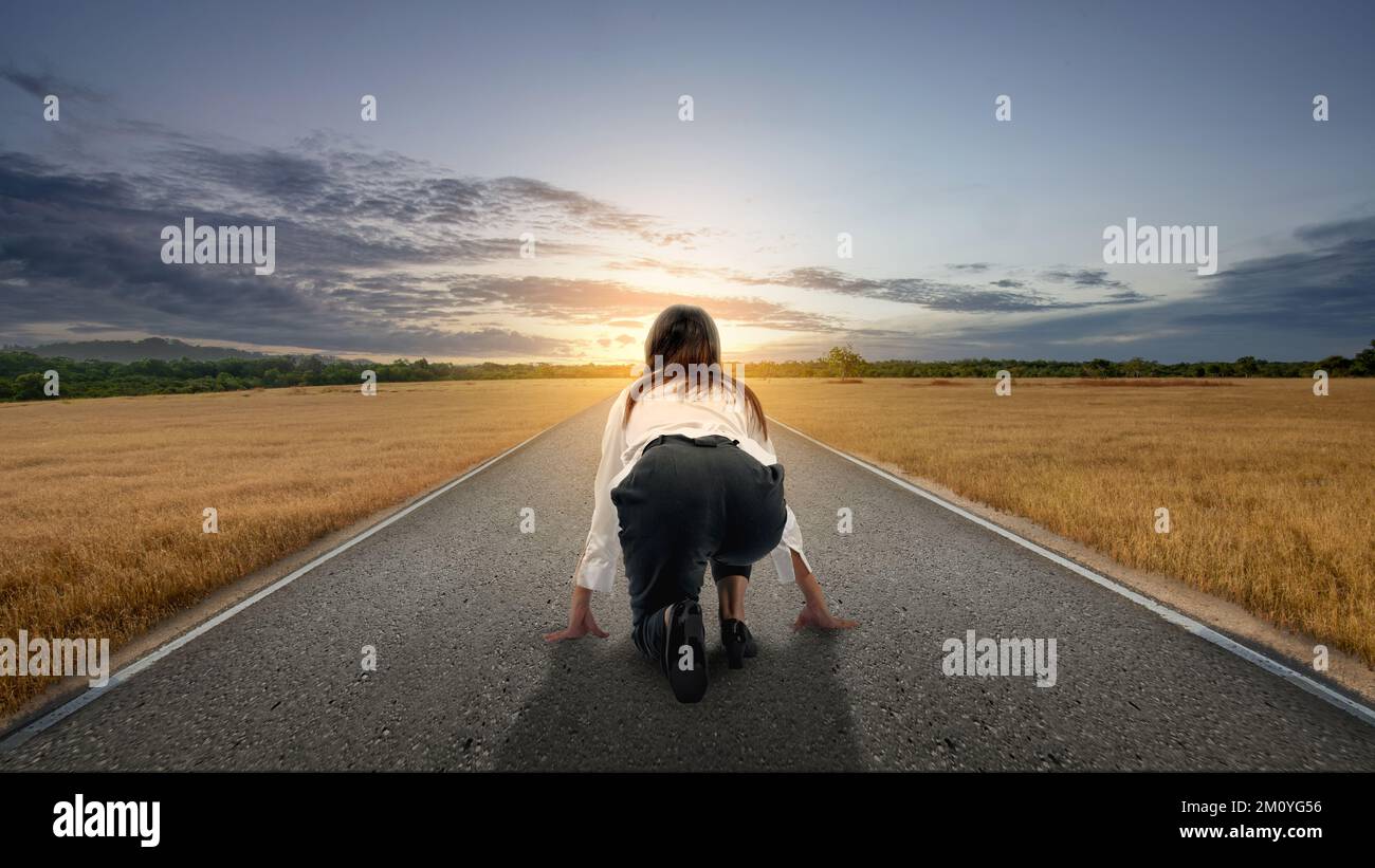 Rear view of Asian businesswoman in start position ready to run on the ...