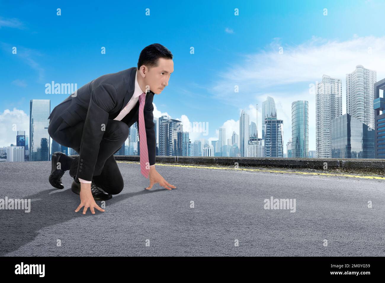 Asian businessman in start position ready to run on the street Stock ...