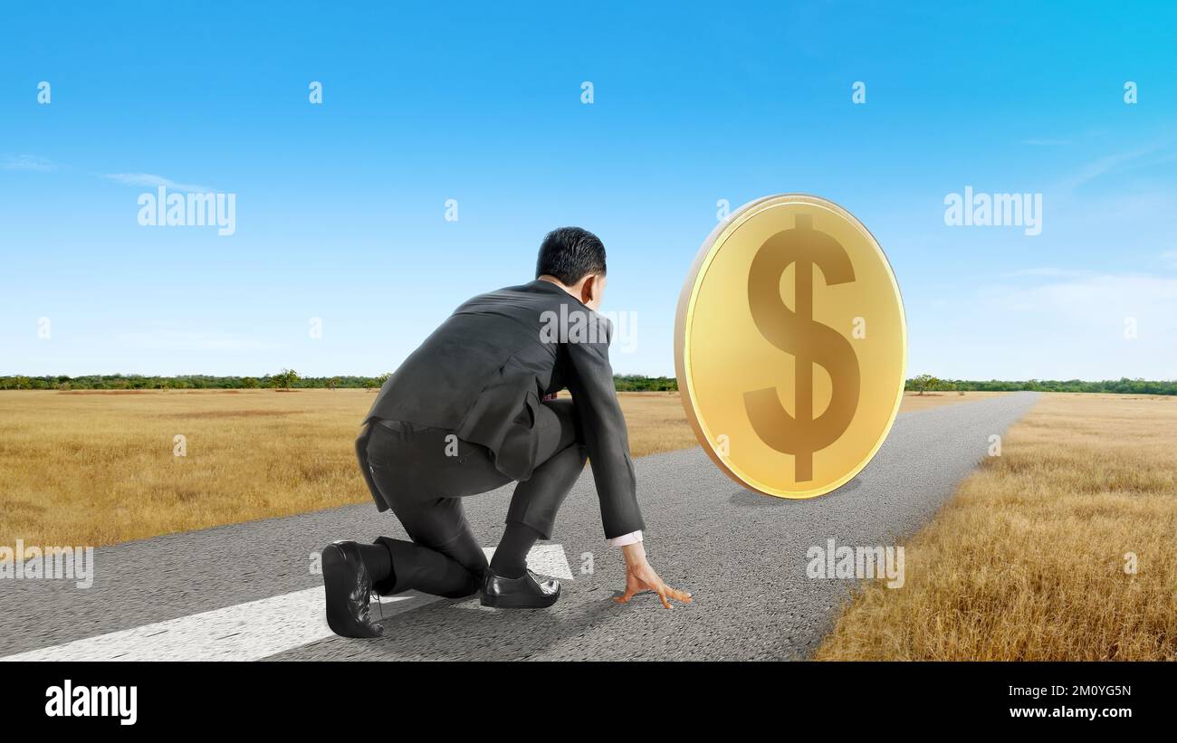 Rear view of Asian businessman in start position ready to run on the ...