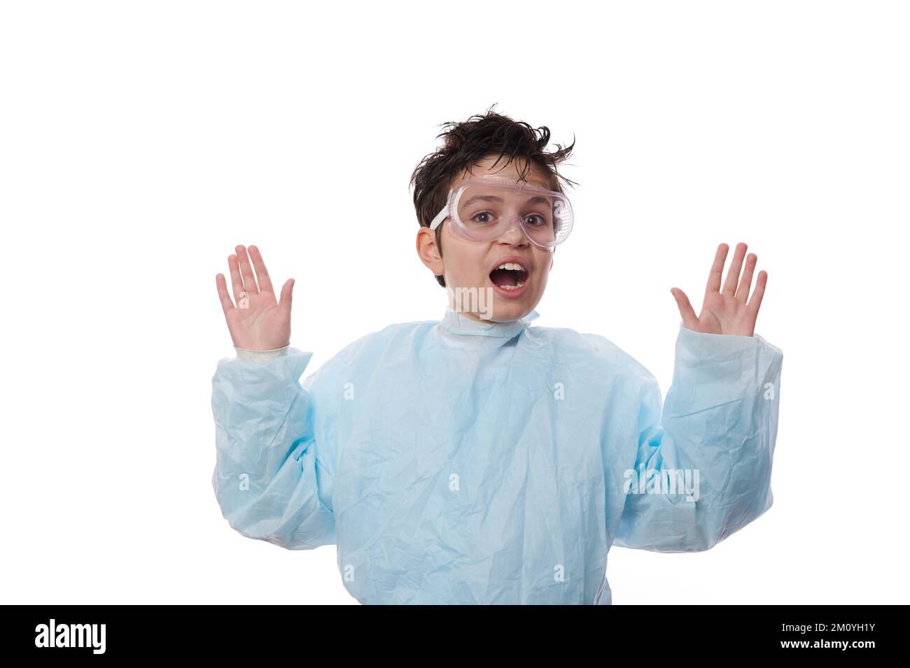 Caucasian elementary school student in lab coat and protective goggles ...