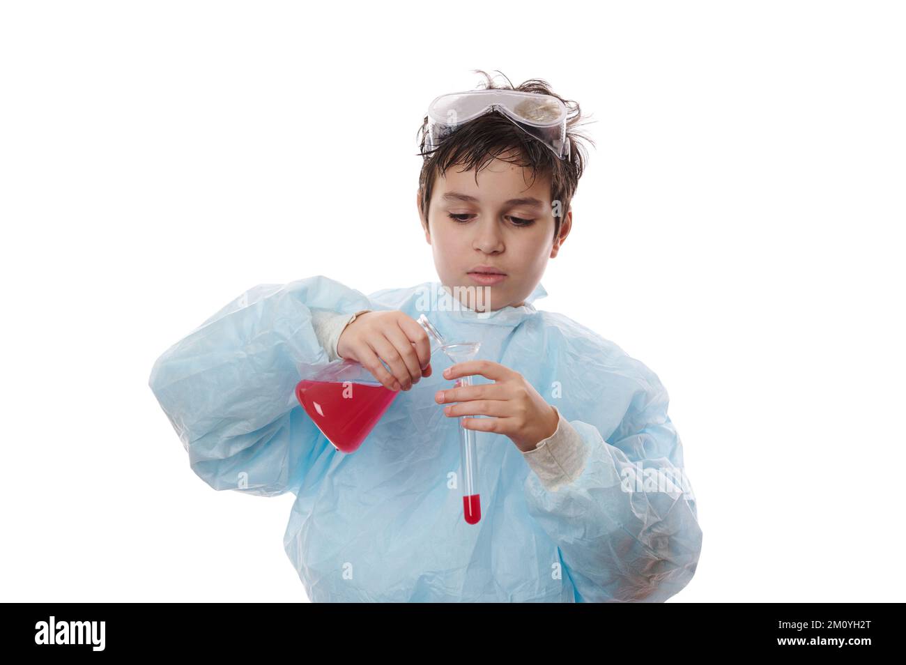 Schoolboy, young scientist-chemist in lab coat, pours red liquid ...
