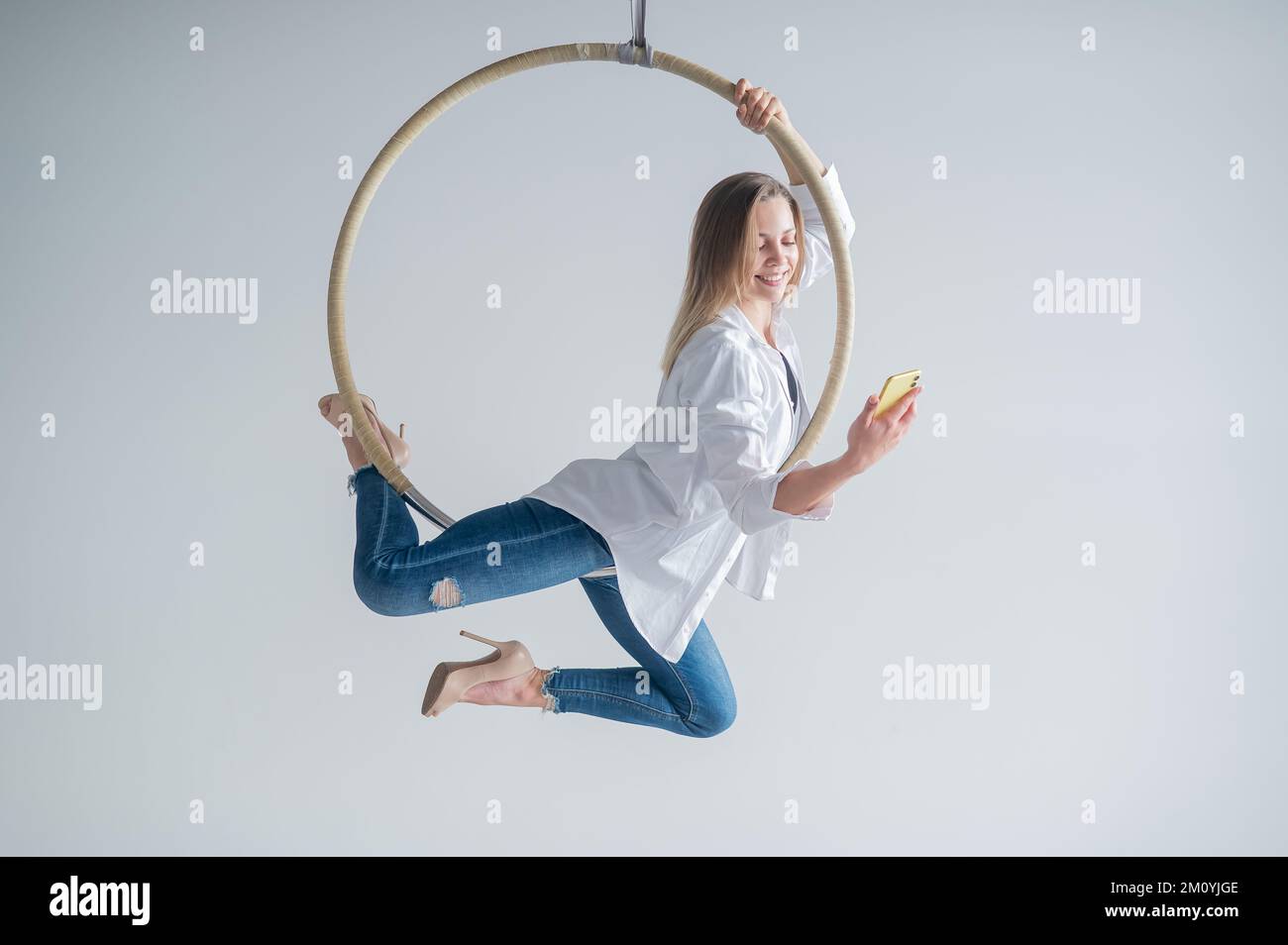 Caucasian female gymnast doing aerial hoop exercises and using ...