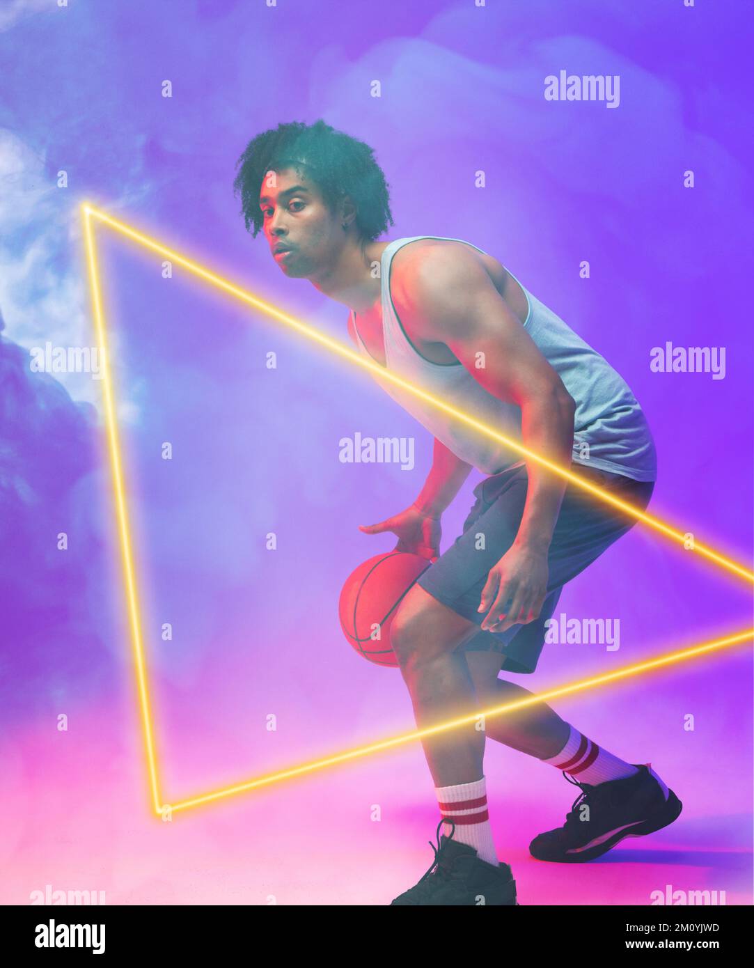 Composite of biracial male player dribbling basketball by glowing ...